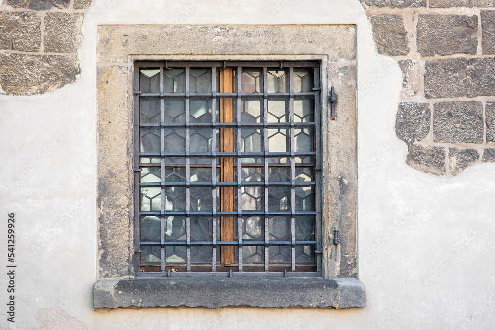 Rectangular window with a metal grate against the background of a ...