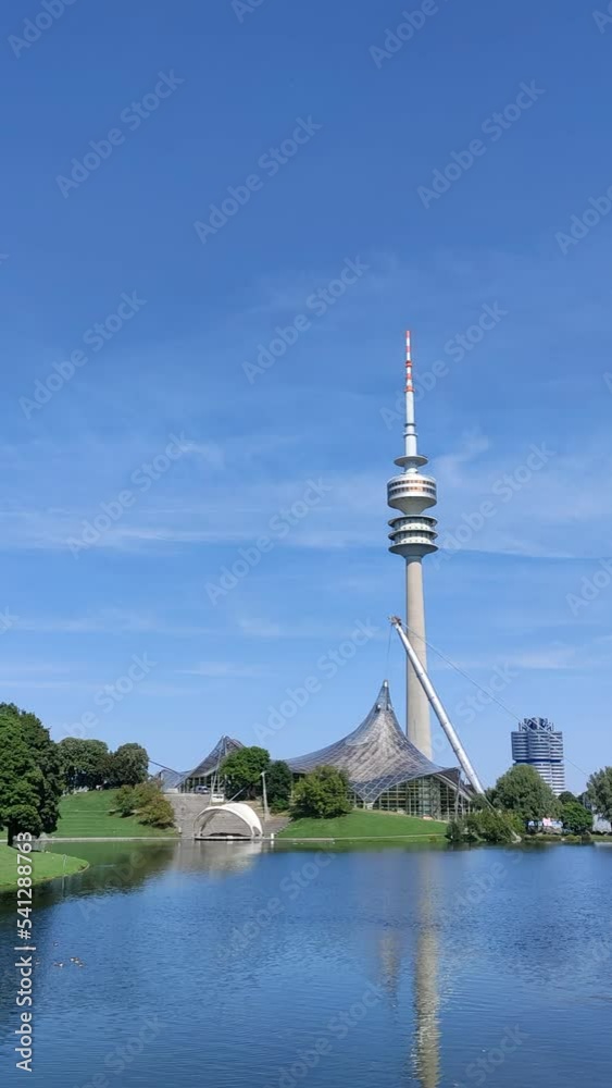 See the Olympic Park Munich tower from the lake with a beautiful blue ...