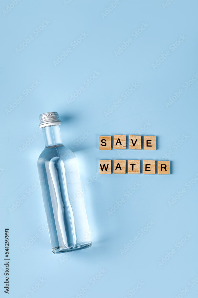 Save water concept. Glass bottle of water on blue background. Clean ...