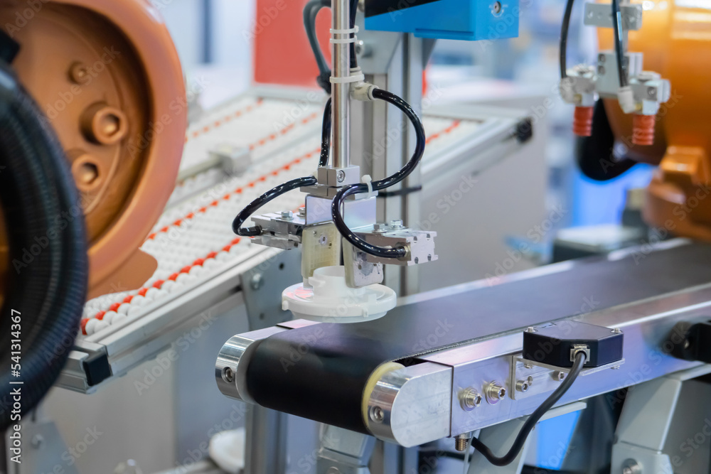 Pick and place robotic arm manipulator moving white plastic detail on ...