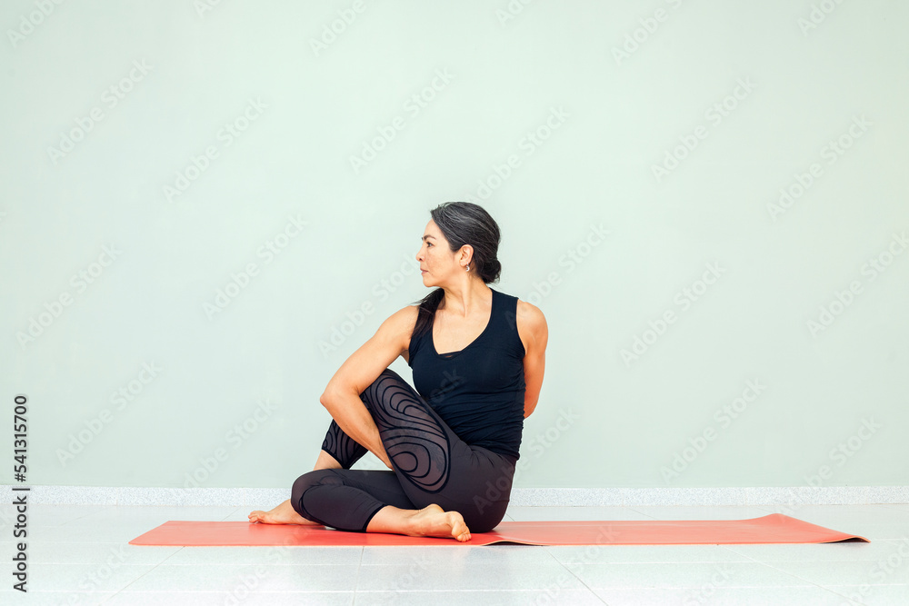 Profile of hispanic mature female in sportswear practicing yoga ...