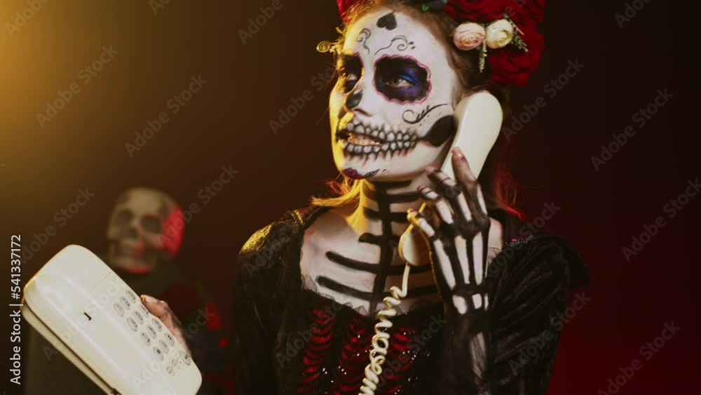 Goddess of death holding landline phone in studio, talking on office ...