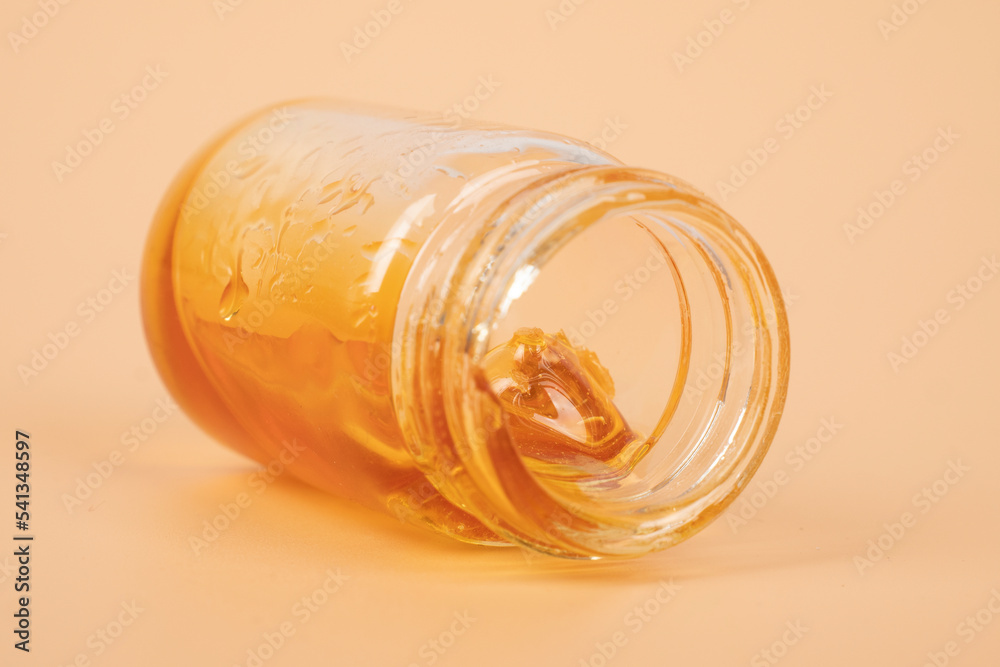 glass jar with brown cannabis wax, pieces of hardened resin of ...