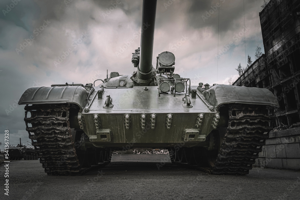Old tank on the background of destroyed houses. The concept of war in ...