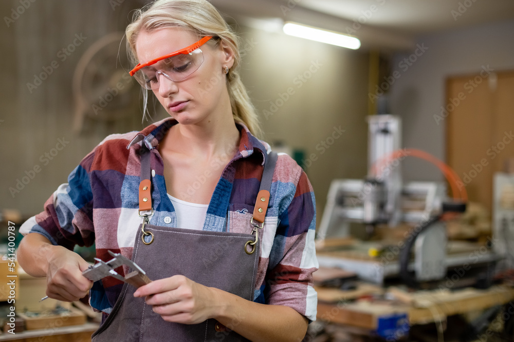 woman worker carpenter or craftsman using vernier calipers measuring ...