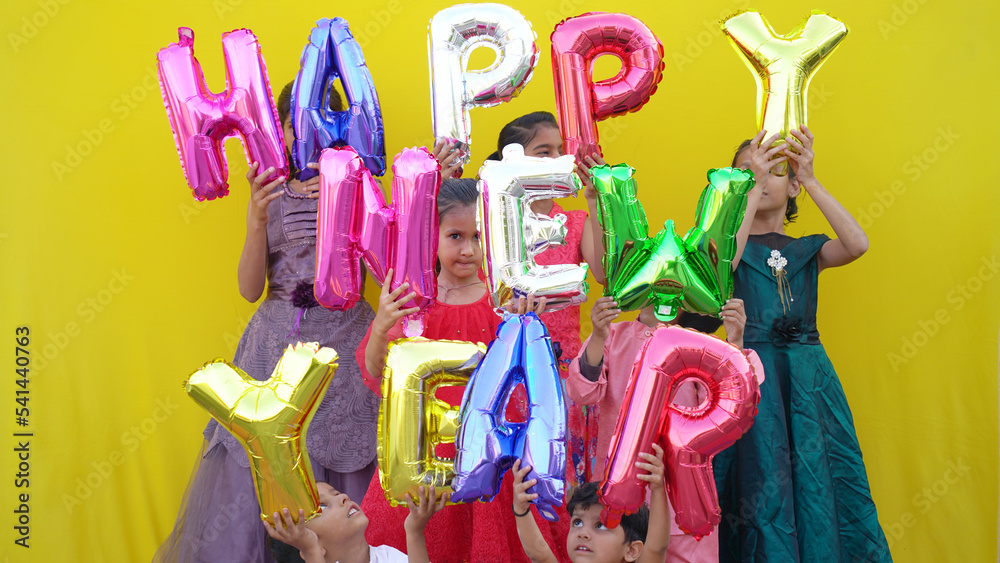 Happy cute little kids smiling and holding Happy New Year alphabets ...