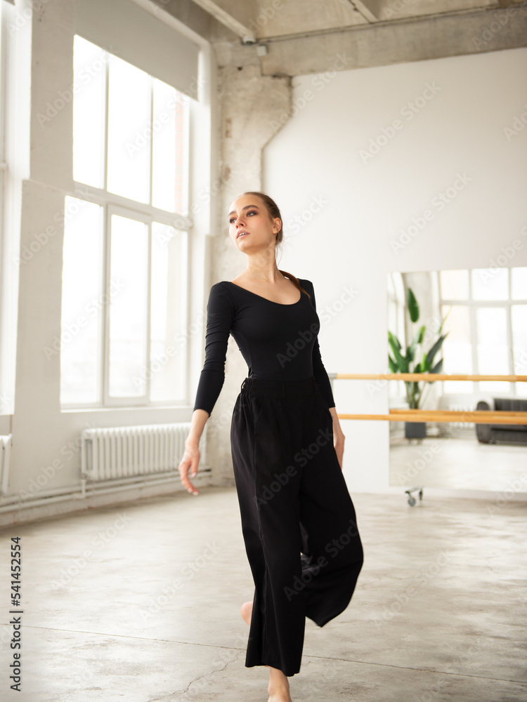 Modern female dancer in black outfit practices in a dance studio Stock ...