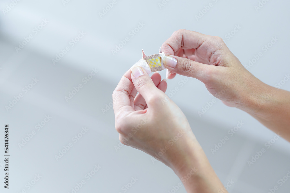 hand putting Adhesive Bandage. band-aid on a cut. isolated on white ...