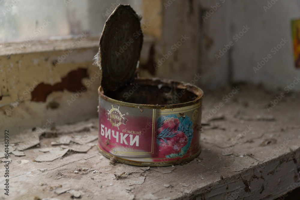Old canned food open over a rusty wooden window corner inside a pripyat ...