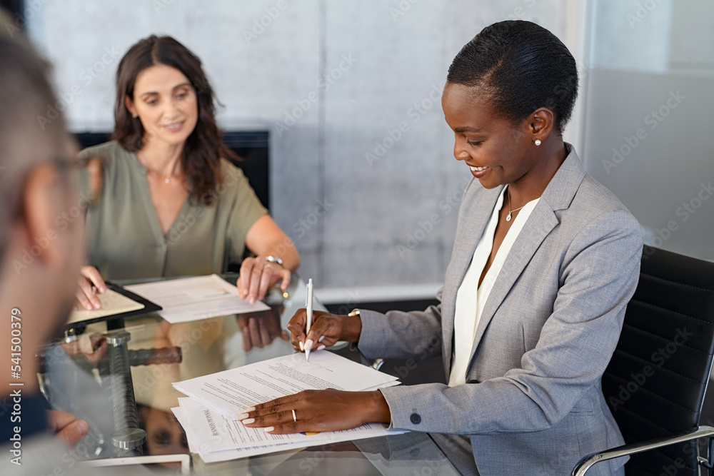 African businesswoman signing document during meeting Stock Photo ...