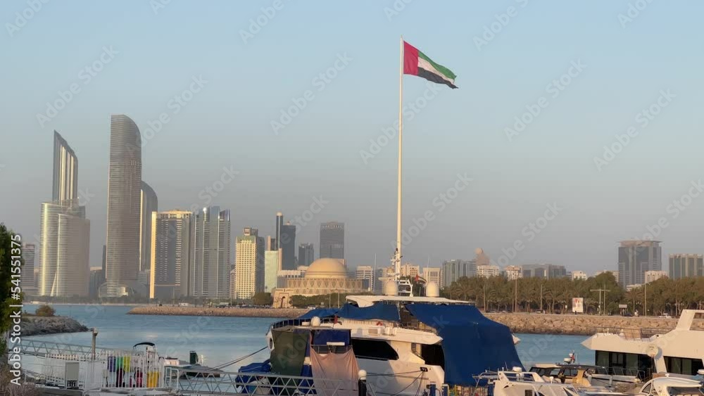 United Arab Emirates flag waving around Abu Dhabi city landmarks ...