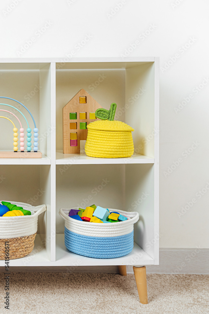 Colorful storage baskets on shelves. White shelving with rainbow wooden ...