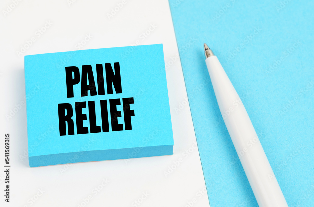 On a white and blue surface, a pen and blue stickers with the ...