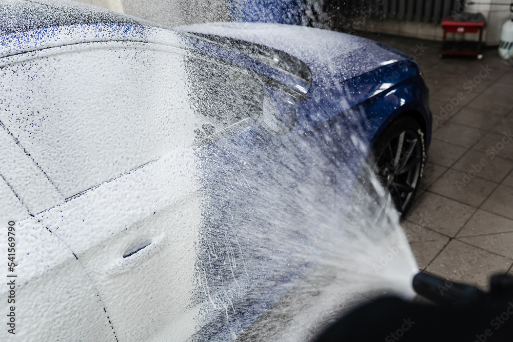 Car washer does full body car wash. Process of spraying foam on the car ...