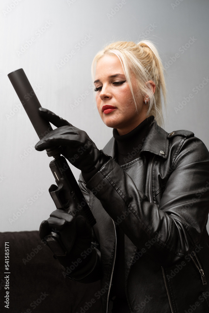 Beautiful girl killer with a pistol with a silencer. Stock Photo ...