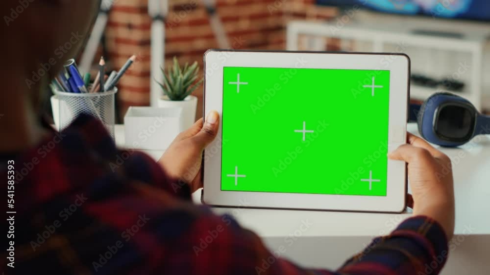 Female freelancer holding digital gadget with horizontal green screen ...