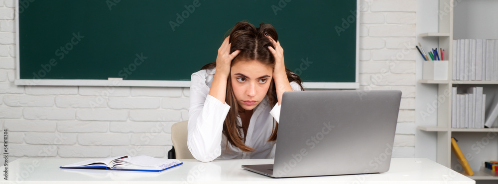 Sad and angry student, cute young school girl using computer at school ...
