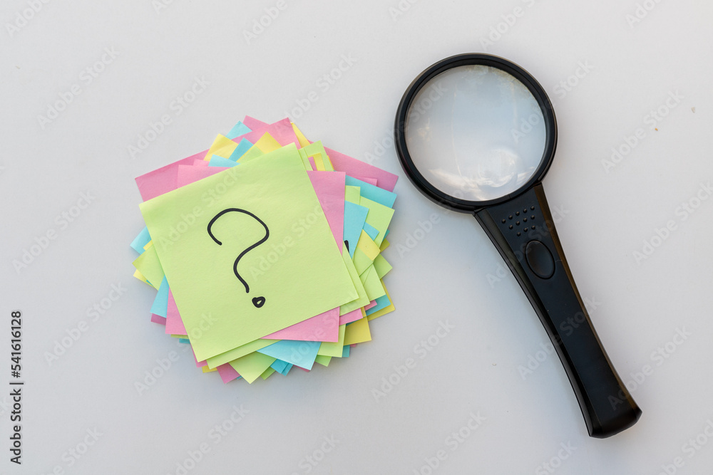 The question mark sign hand written on a sticky note along a searching ...
