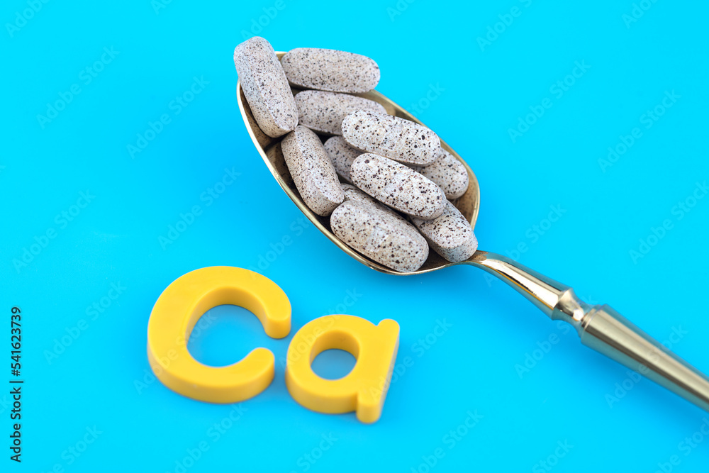 Calcium tablets and symbol Ca on blue background Stock-Foto | Adobe Stock