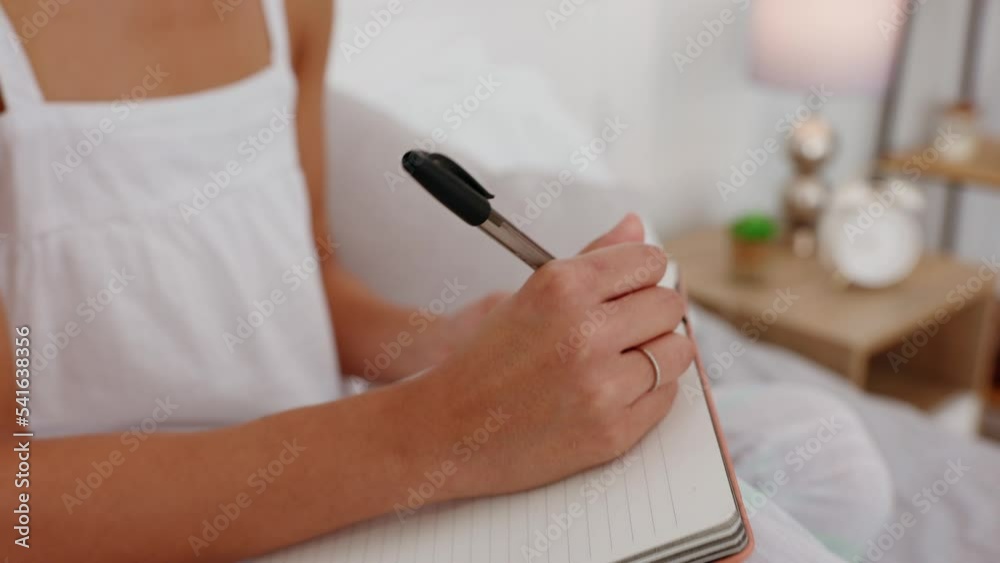 Hand, book and woman writing on a bed for creative, brainstorming and ...