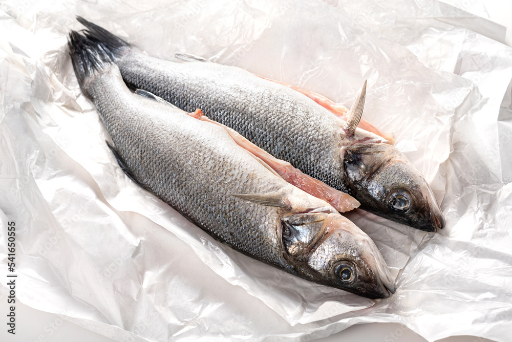 Sea bass fish. Two peeled raw sea bass on wrapping paper Stock Photo ...