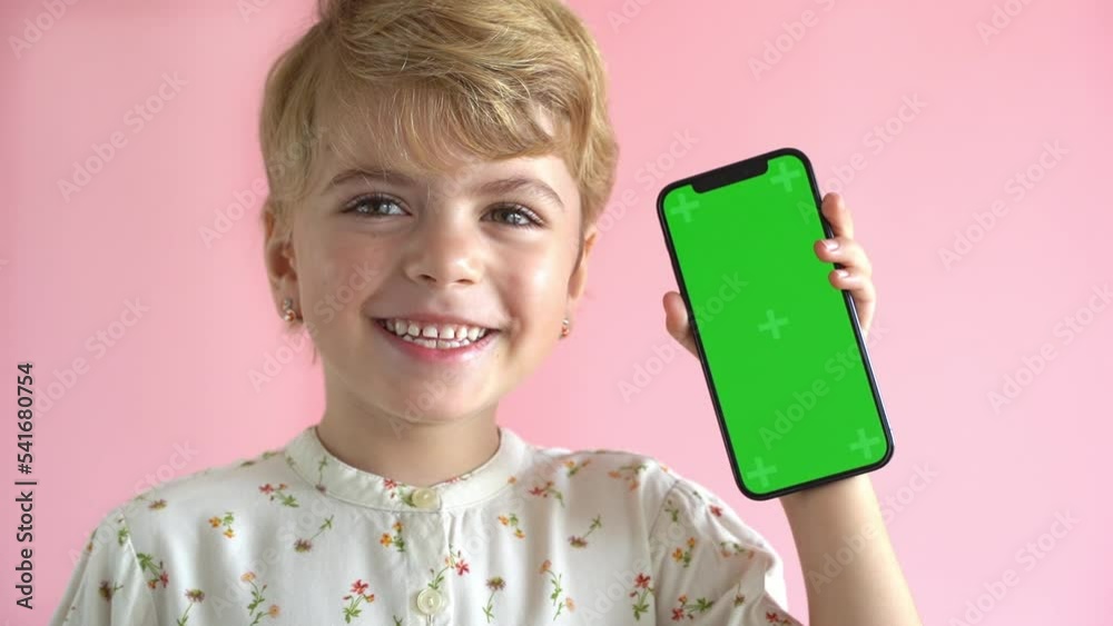 Little cute girl laugh hold smartphone green screen chroma key over ...