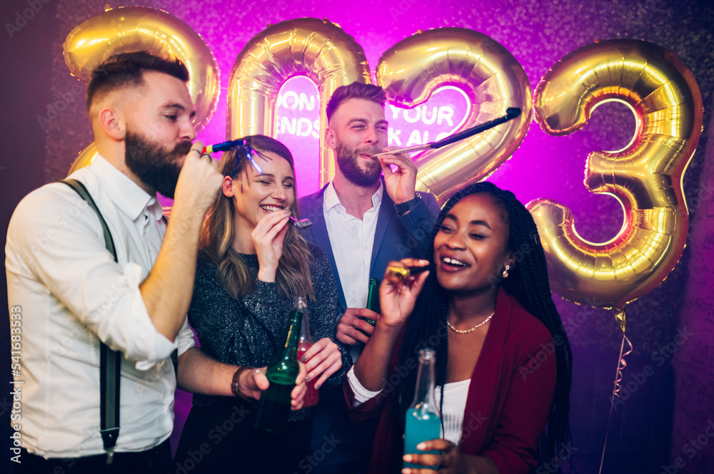 Multiracial people with party trumpets and drinks celebrating new years ...