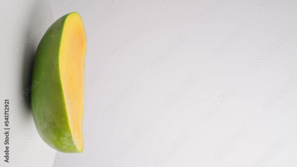 Ripe juicy sweet yellow mango rotate on white background close-up ...