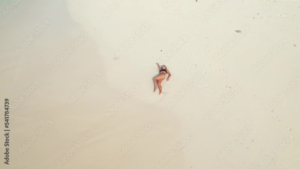 Drone Flyover Aerial Shot Of Woman Lying On Sandy Beach Ocean Waves