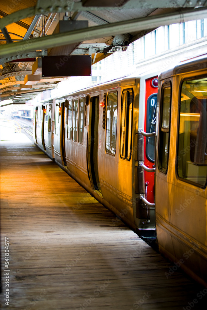 An elevated commuter transit train pulls into a station and waits for ...