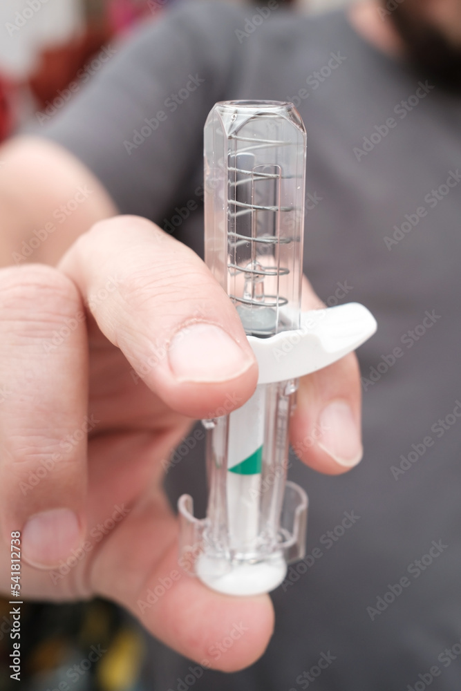 Safe syringe in the hand, with spring mechanism to retract the needle ...