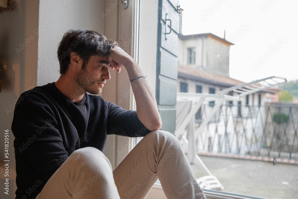 Lonely isolated young man sitting on the floor meditating. Depression ...