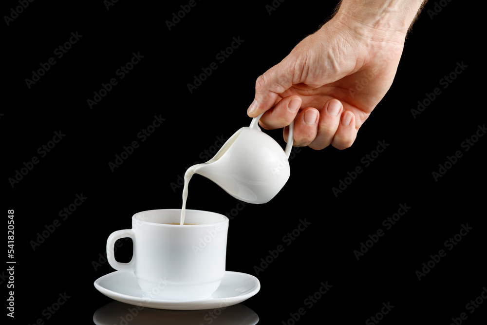 Coffee with milk. Milk is poured into a cup with coffee. Adding milk to ...