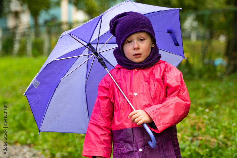 Child with an umbrella walks in the rain. Little boy with umbrella ...