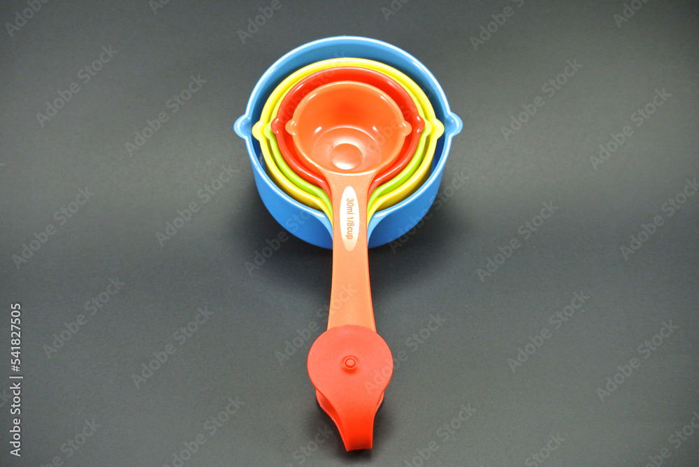 Colorful measurement cup with different volume on black background ...