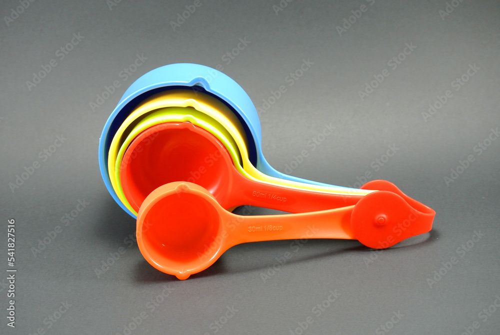 Colorful measurement cup with different volume on black background ...