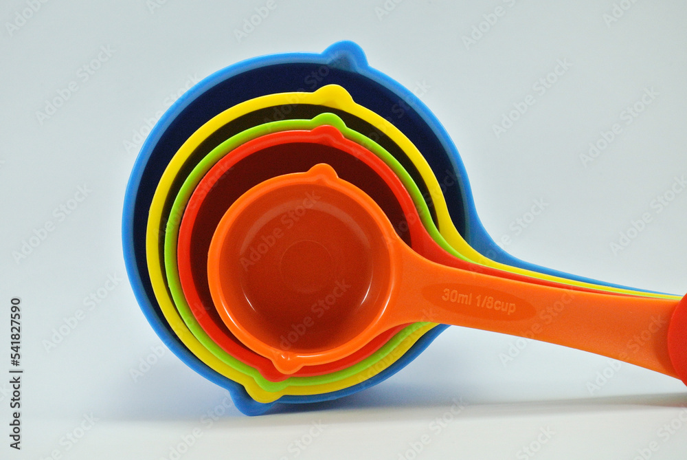 Colorful measurement cup with different volume on white background ...