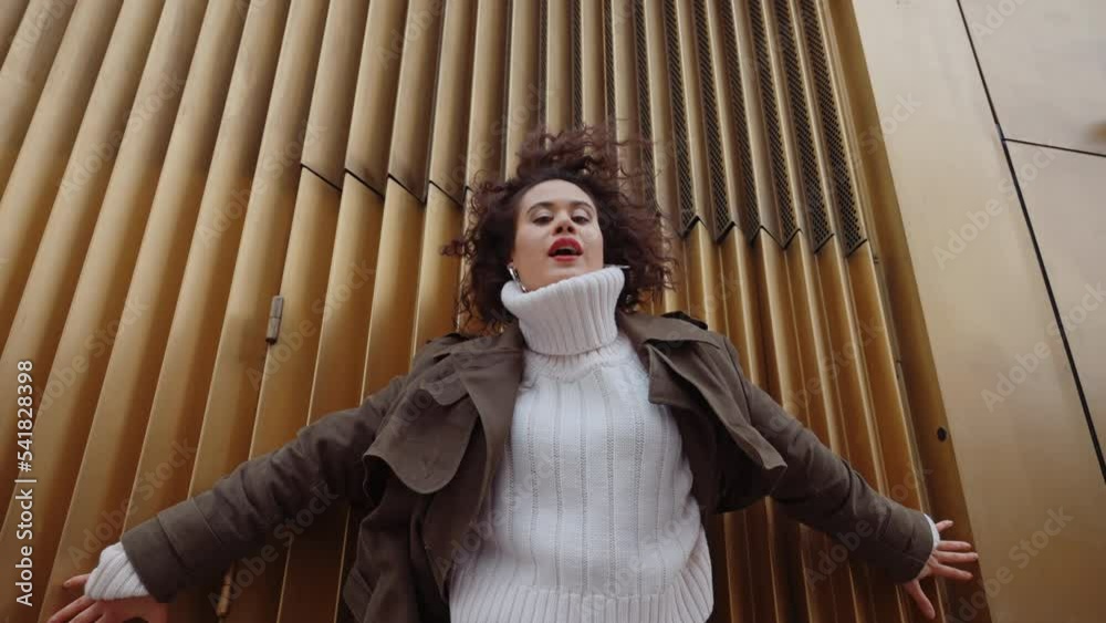 Slow motion urban style young female model in autumn coat posing with ...