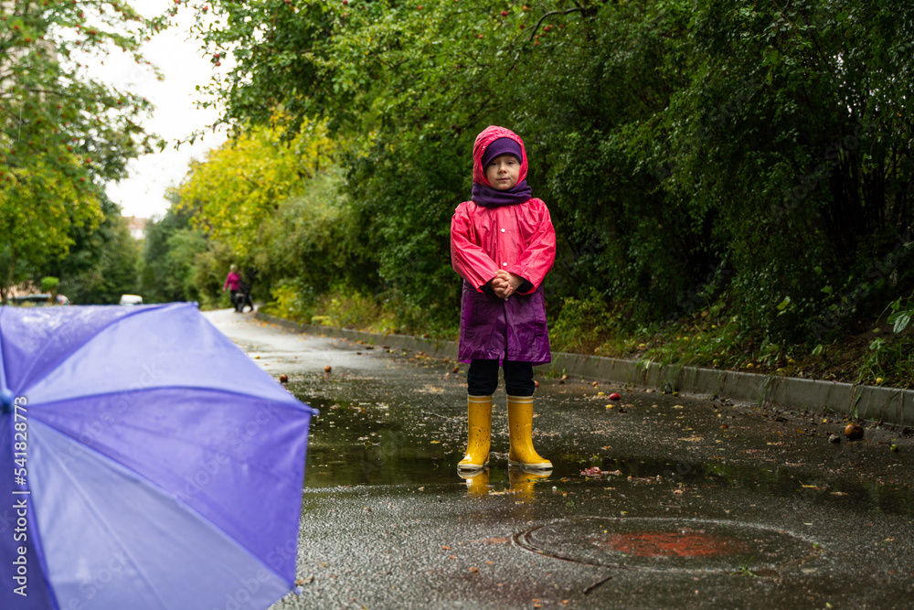 Child playing in autumn rain. Kid with umbrella. Outdoor fun for kids ...