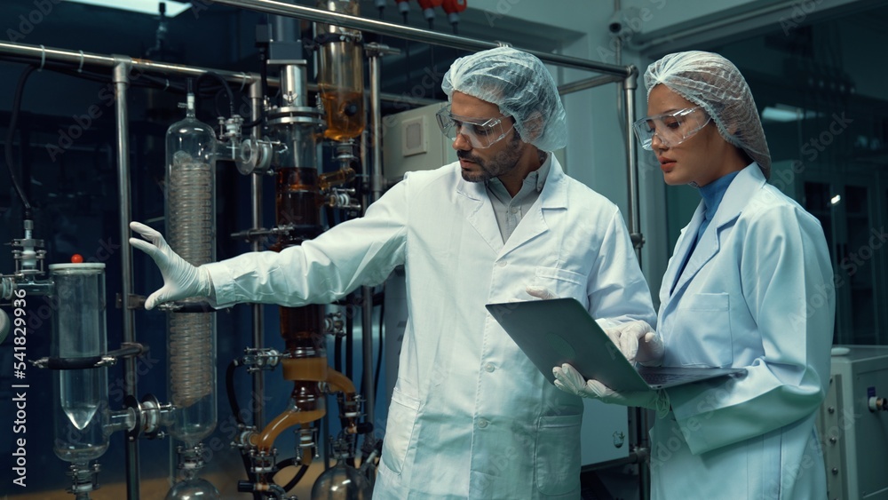 Two scientist in professional uniform working in laboratory for ...