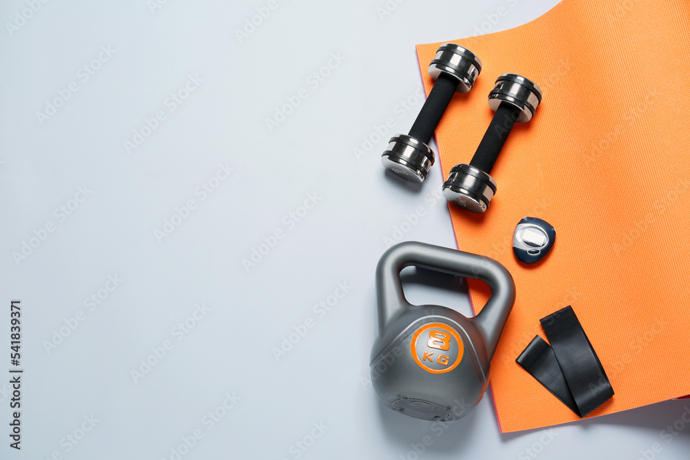 Exercise mat and other sport equipment on white background, flat lay ...