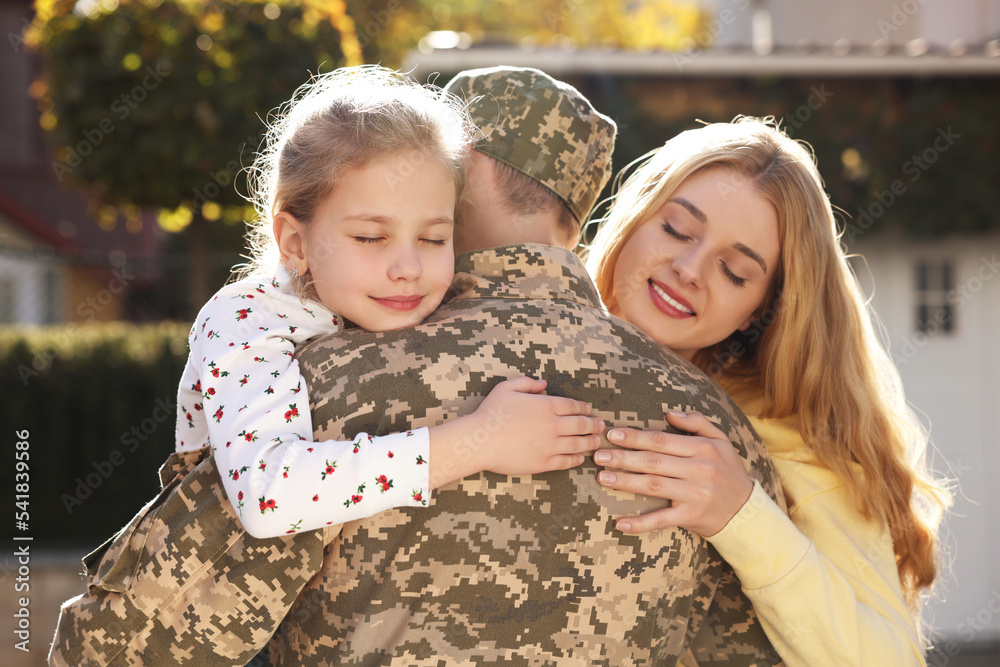 Daughter and wife hugging soldier in Ukrainian military uniform ...