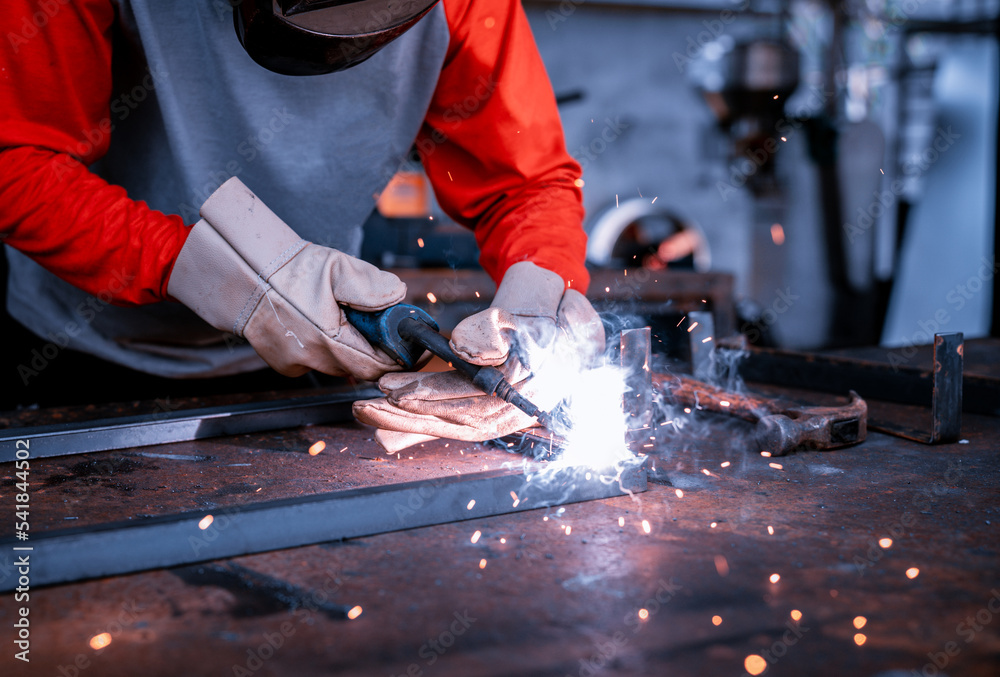 Close-up, welders wear gloves while using welding machines to weld ...