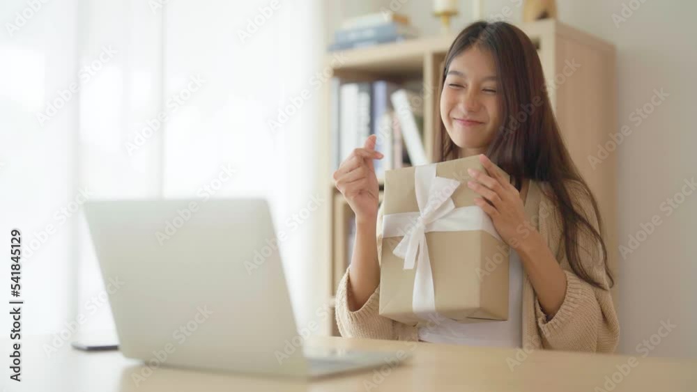Young asian woman using computer laptop at home. Female showing gift ...