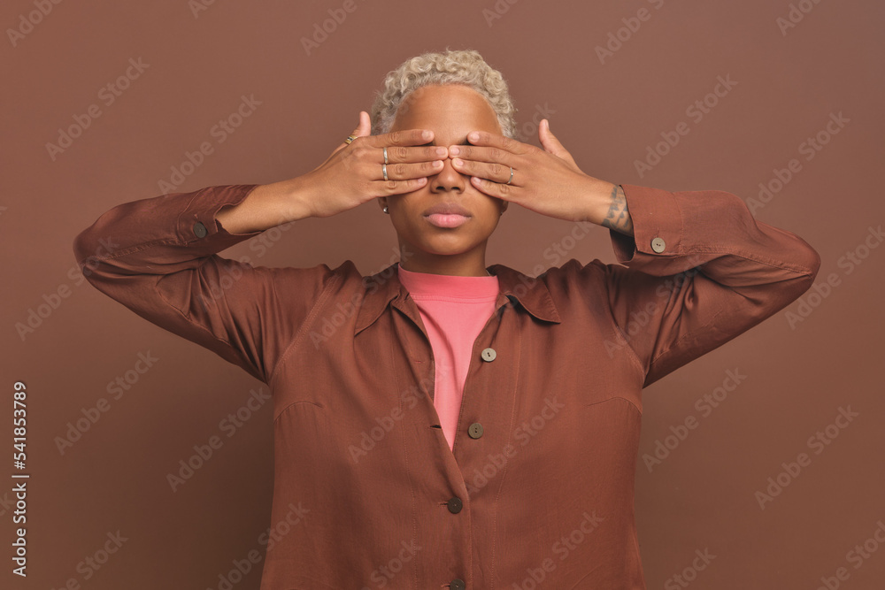 Young serious pretty African American woman covers eyes with palms to ...