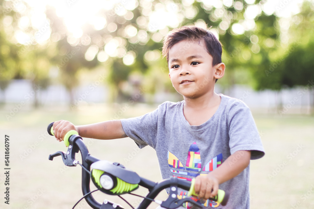 Happy and smiling kid boy riding a bycicle in Park Stock Photo | Adobe ...