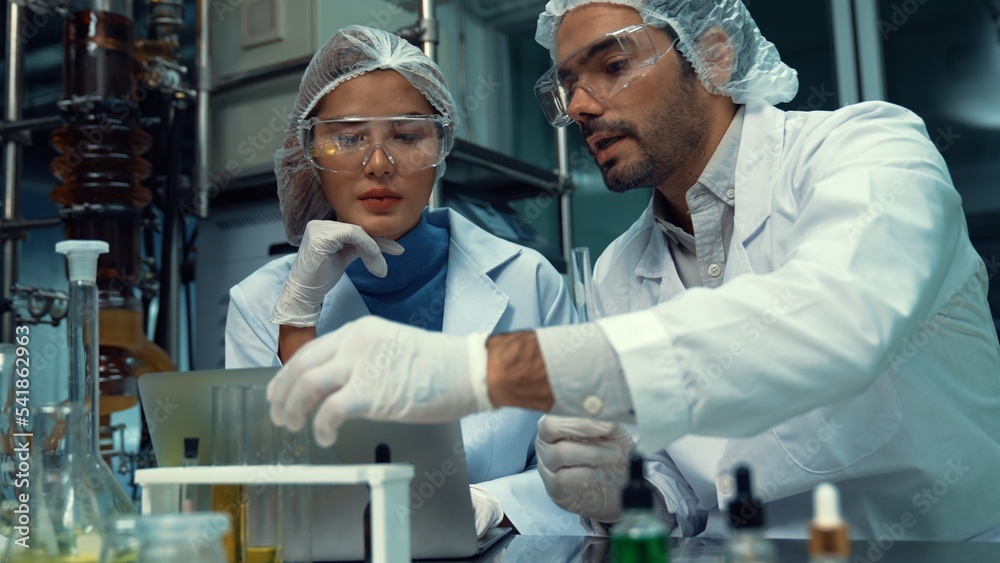 Two scientist in professional uniform working in laboratory for ...