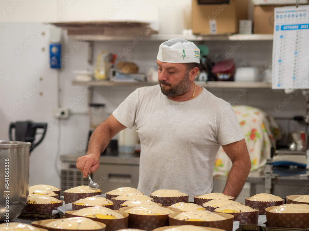 artisan italian baker preparing panettone christmas cake adding almonds ...