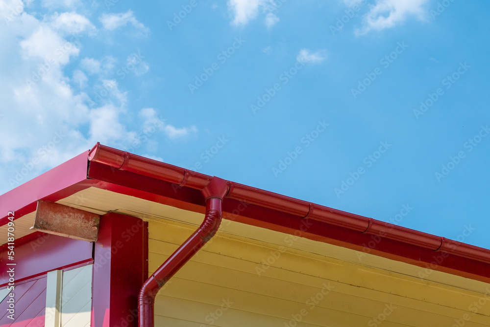 Red gutter on the roof top of house. Stock 写真 | Adobe Stock