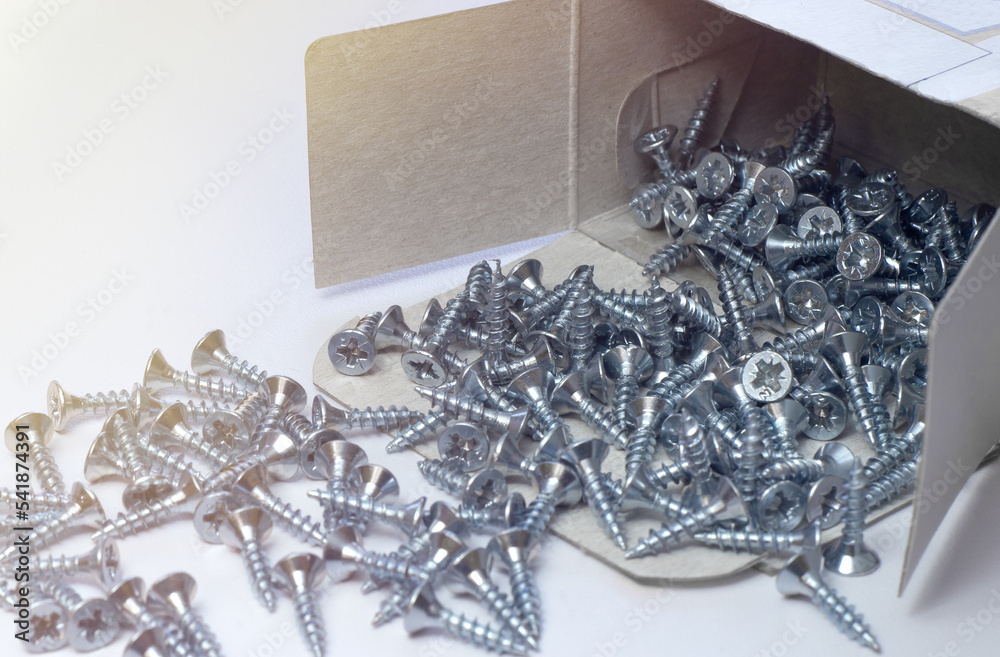 Metal screws for mounting. Cardboard box with screws on the table. Self ...